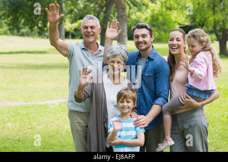 Happy extended family waving hands at park Stock Photo - Alamy
