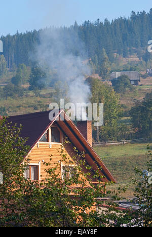 Smoke from chimney. Smoke in sky. Home heating. Pipe on roof of house ...