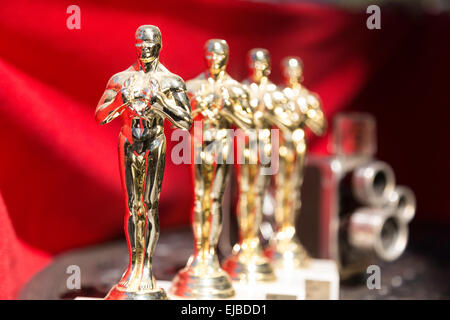 Golden replica of an Oscar film award on a black plinth isolated on ...