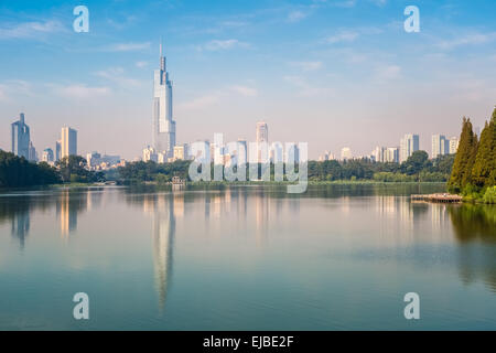 Modern building is reflected in lake in city Park. Summer Sunny day in ...