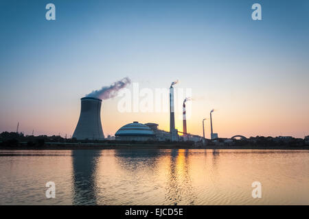 Coal-fired power station at sunset, cooling towers billowing out steam ...