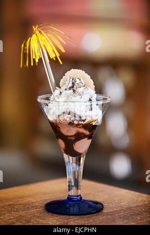 ice cream sundae in chocolate glaze in a plate on a blue background ...
