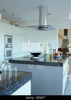 Granite topped island unit in cottage kitchen with collection of blue ...