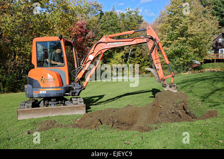 Mini excavator excavates a yard Stock Photo - Alamy