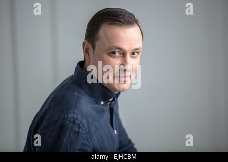 Man sitting with a slight smile and looking at the camera Stock Photo ...