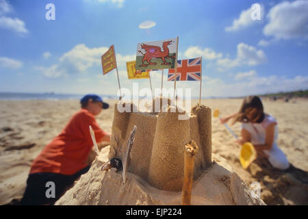 Traditional British sand castle with Union Jack flags on a beach in ...
