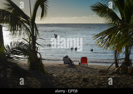Beach goers enjoying the final hours before the sundown at Jobos beach ...
