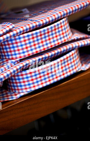 Fashion shirts on shelf in clothing store Stock Photo - Alamy