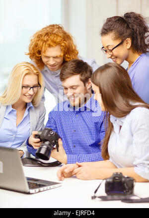 smiling team with photocamera in office Stock Photo - Alamy