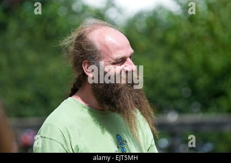 A man sports a long straggly beard and a ponytail Stock Photo - Alamy