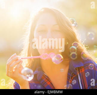 Young woman blowing bubbles Stock Photo - Alamy