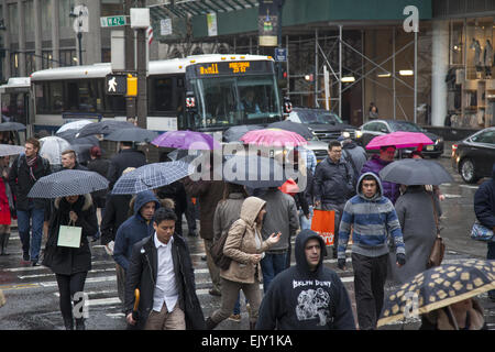 The street remains busy with umbrellas up on a rainy day in midtown ...