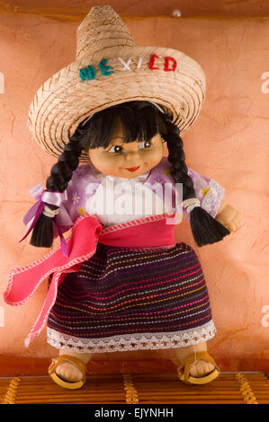 Small doll with Mexican woman figure next to a blank card with Mexican ...