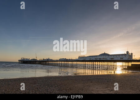 Beach during a low tide at sunset with a rock breakwater in the ...