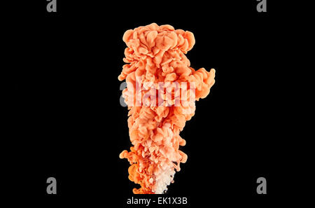 Clay colored ink making smoke patterns in water on black background ...