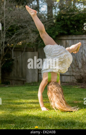 eight year old girl doing cartwheels in school uniform dress after ...