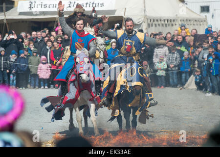 Actors dressed as knights ride across a square during a medieval castle ...