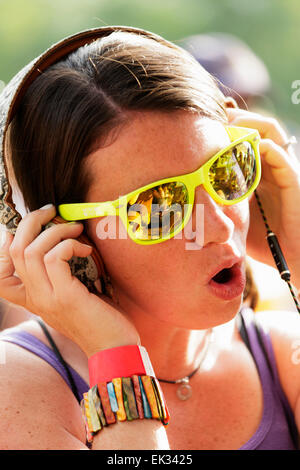 Young woman in headphones listening to music on pink background Stock ...