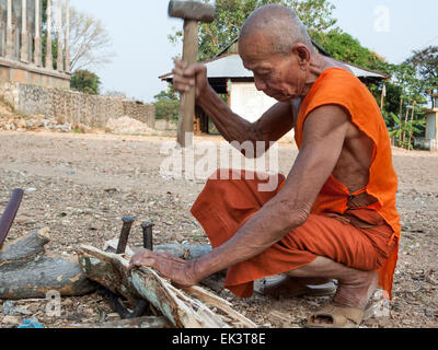 Buddhist monk cutting wood trunk in Kep pagoda, Cambodia Stock Photo ...