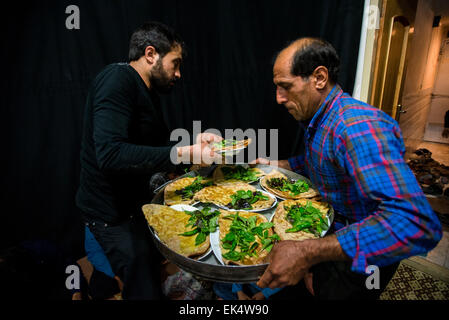Participants of Tazieh, ritual theater of the day of Ashura, eat beryun ...