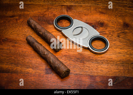 Italy, italian cigars (toscani) and a cigars cutter on a wooden table ...