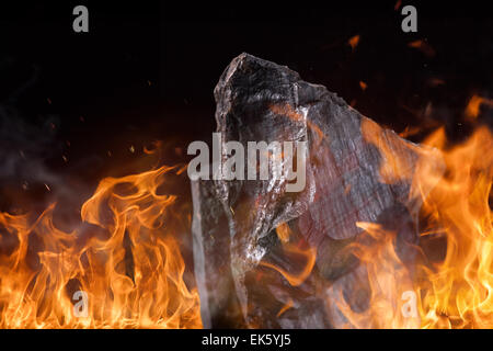 Coal lumps with fire flames on dark background Stock Photo - Alamy