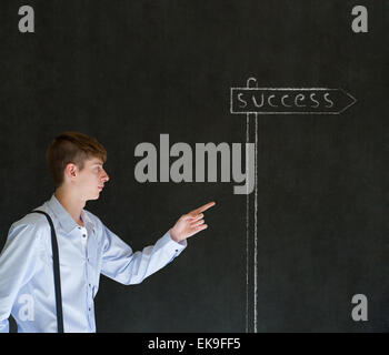 Business man with chalk success road street sign on blackboard ...