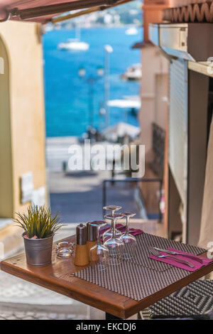A table at an outdoor restaurant with a view of boats in the marina on ...