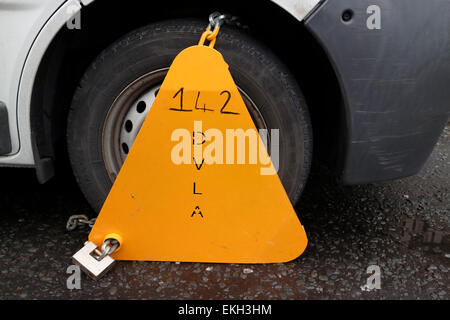 Clamped car wheel. DVLA wheel clamp attached to a car due to unpaid ...