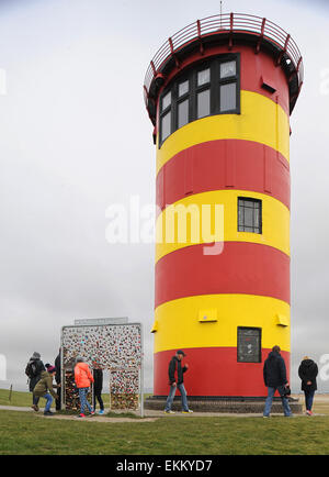 Pilsum, Germany. 08th Apr, 2015. Tourists look at the red and yellow ...