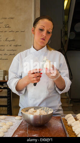 Beautiful young brunette pastry chef woman cooking pastries at the ...