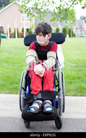 mixed race little boy with cerebral palsy in the classroom with his ...