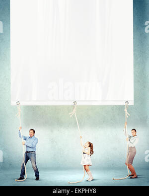 Family pulling banner Stock Photo - Alamy
