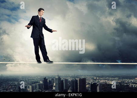 Image of pretty businessman balancing on rope Stock Photo - Alamy