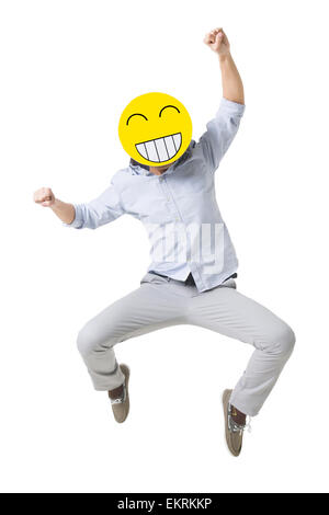 Young man jumping with a happy emoticon face in front of his face Stock ...