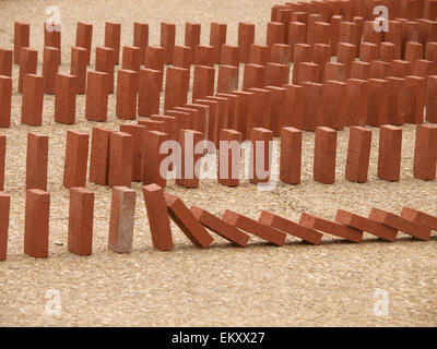 Bricks tumble and topple one after the other, the domino effect, or ...