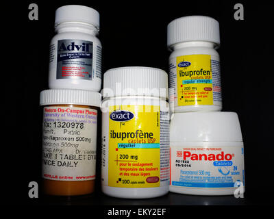 A selection of painkiller bottles photographed against a black ...