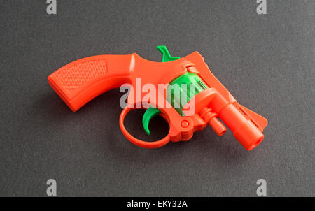 A bright orange toy cap gun on a white background Stock Photo - Alamy
