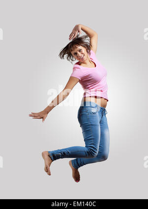 pretty modern slim hip-hop style woman jumping dancing on a colour ...