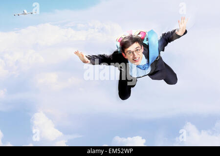 Conceptual image of young businessman flying with parachute on back ...