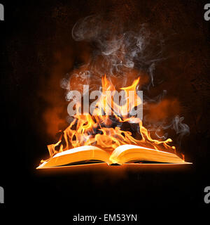 Image of opened burning book against black background Stock Photo - Alamy