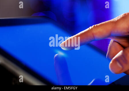 Close up of finger touching blue toned screen on tablet pc Stock Photo ...
