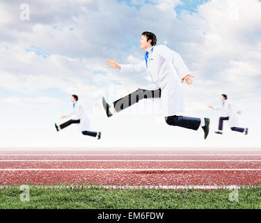 Funny image of young running doctor in white uniform Stock Photo - Alamy