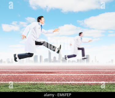 Funny image of young running doctor in white uniform Stock Photo - Alamy