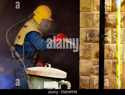 Worker sandblasting stone wall Stock Photo - Alamy