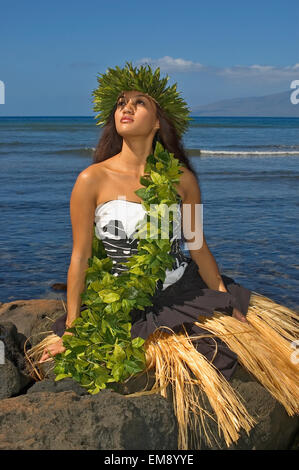 Hula Dancer With Haku Lei In Traditional Outfit On Rocky Coast Holding
