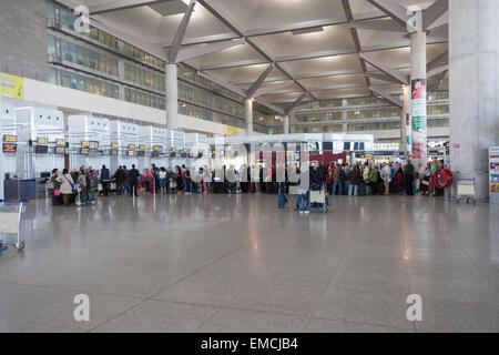Passengers queing at a check in desk at Malaga Airport Spain Stock ...