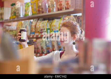 Female shop assistant sorting merchandise in wholefood shop Stock Photo ...