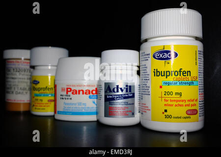 A selection of painkiller bottles photographed against a black ...