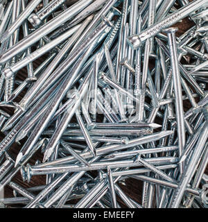 iron nails on wooden background Stock Photo - Alamy